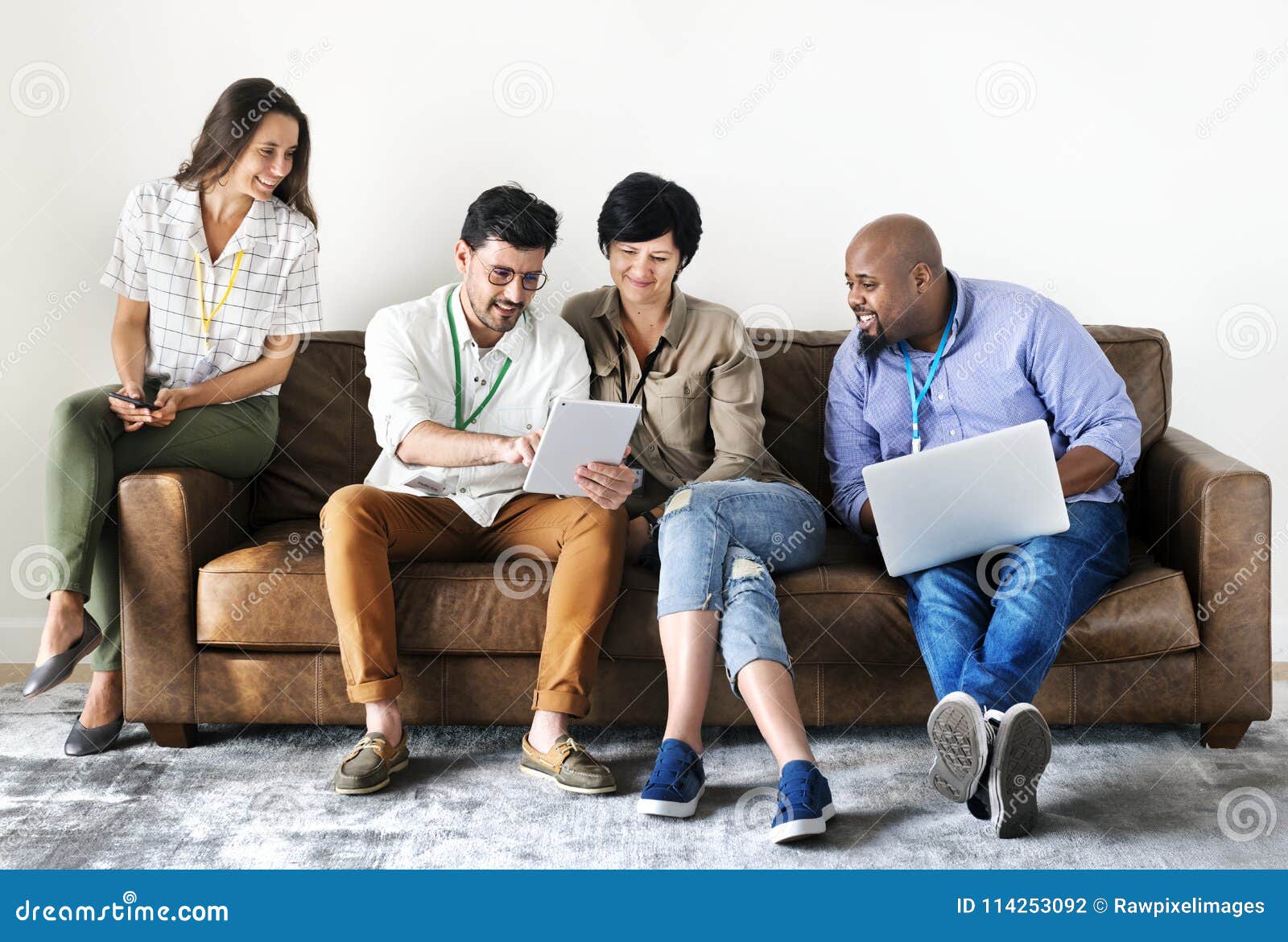 Workers Working on Gadgets Sitting on Couch Stock Photo - Image of ...