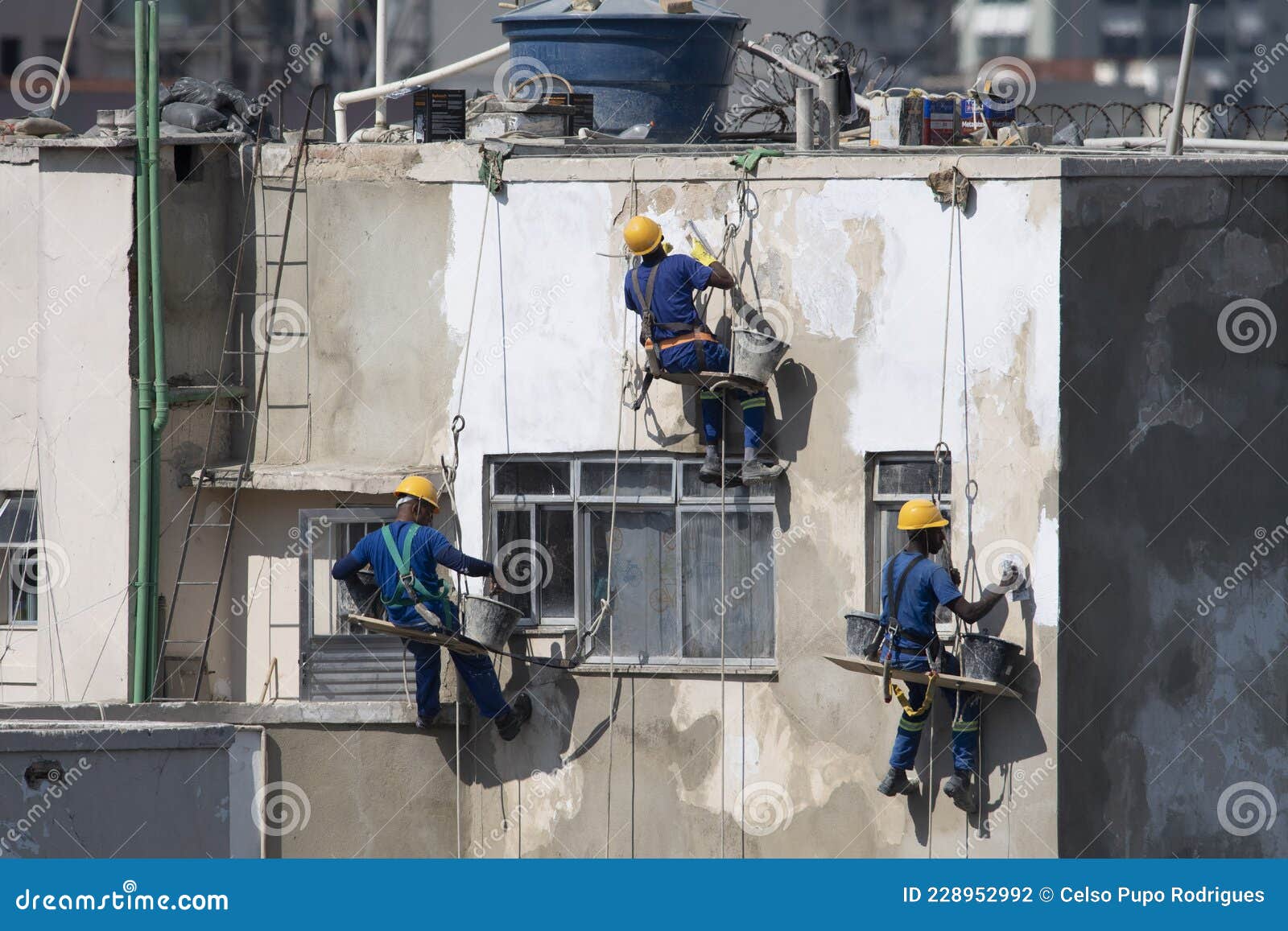 Workers Working on Restoration of a Building Facade, Hanging from Ropes ...