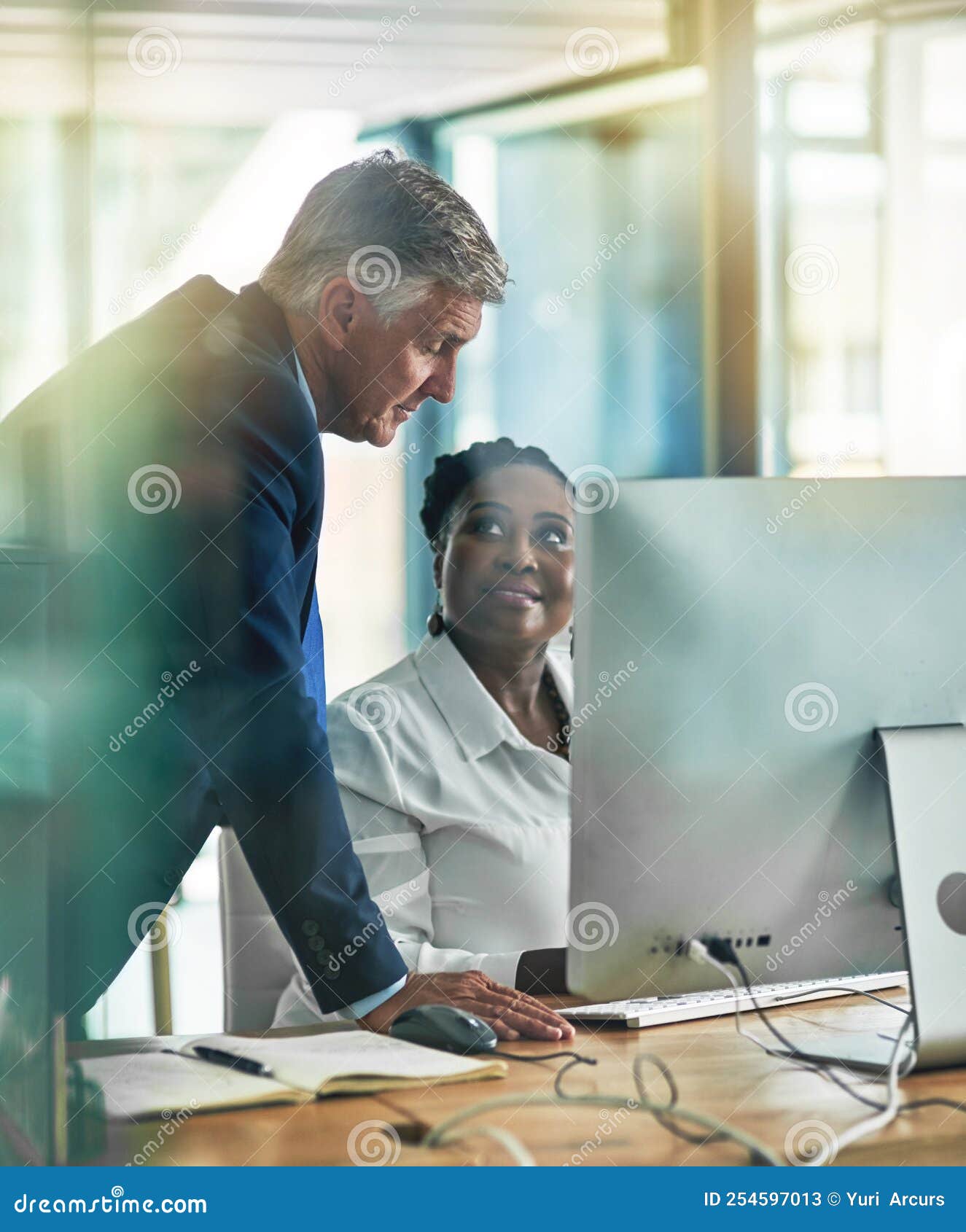 Working Better Together. Two Businesspeople Working Together at a ...