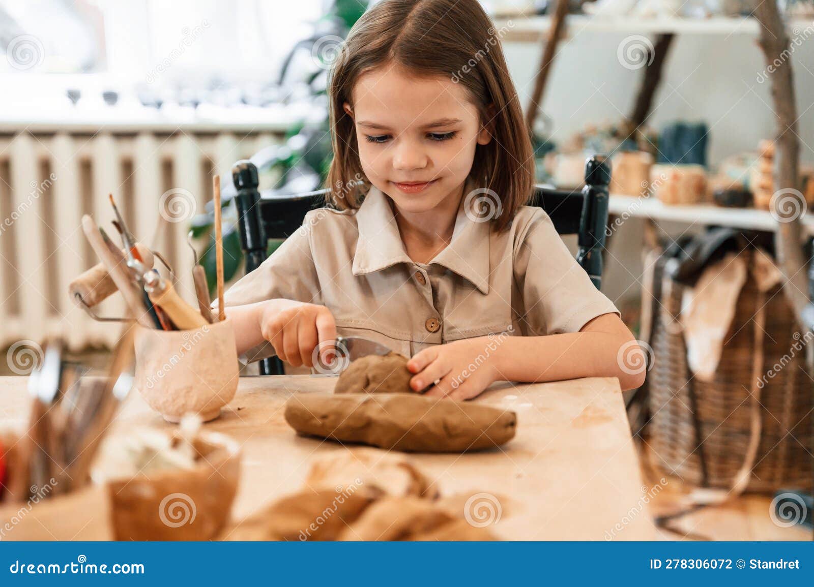 Working with Clay. Little Girl is Learning How To Do Pottery in the ...