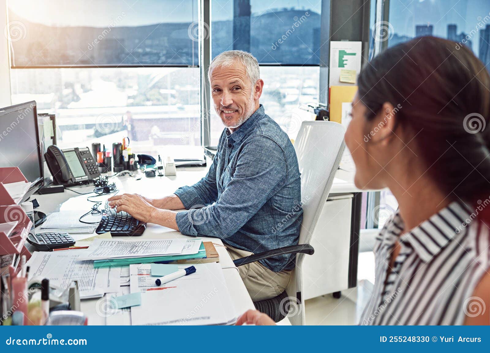 Working Closely with a Colleague. Two Colleagues Working in the Office ...