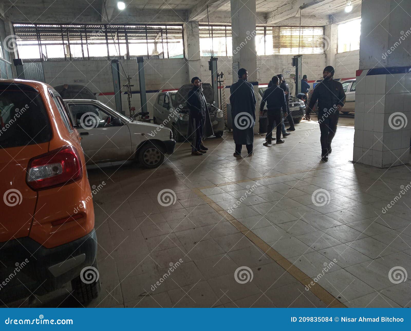 An Indian Old Mechanic Putting Grease Oil Into The Truck Wheel During ...