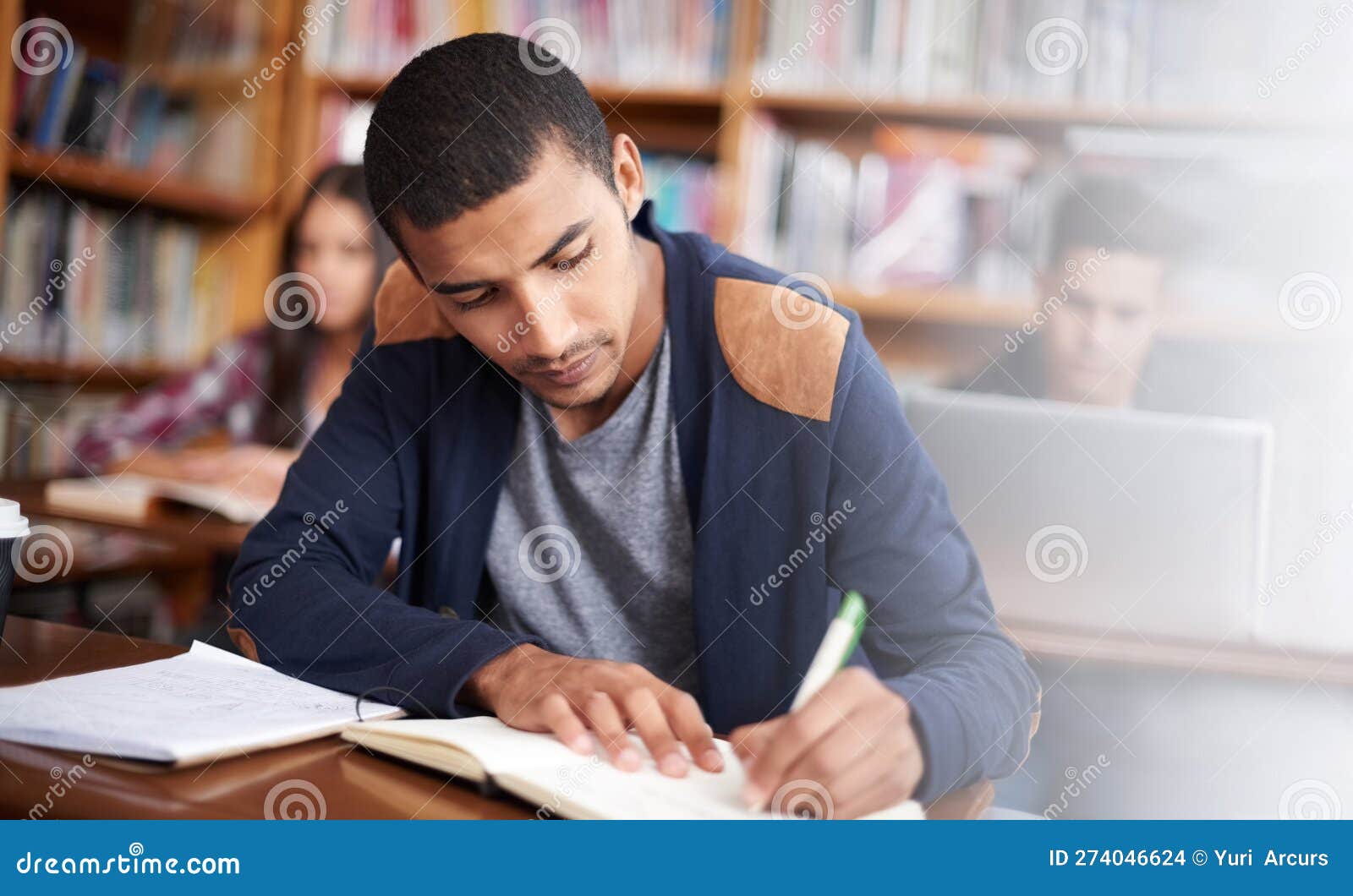 Working Diligently. a Handsome Young Student Working Diligently in His ...