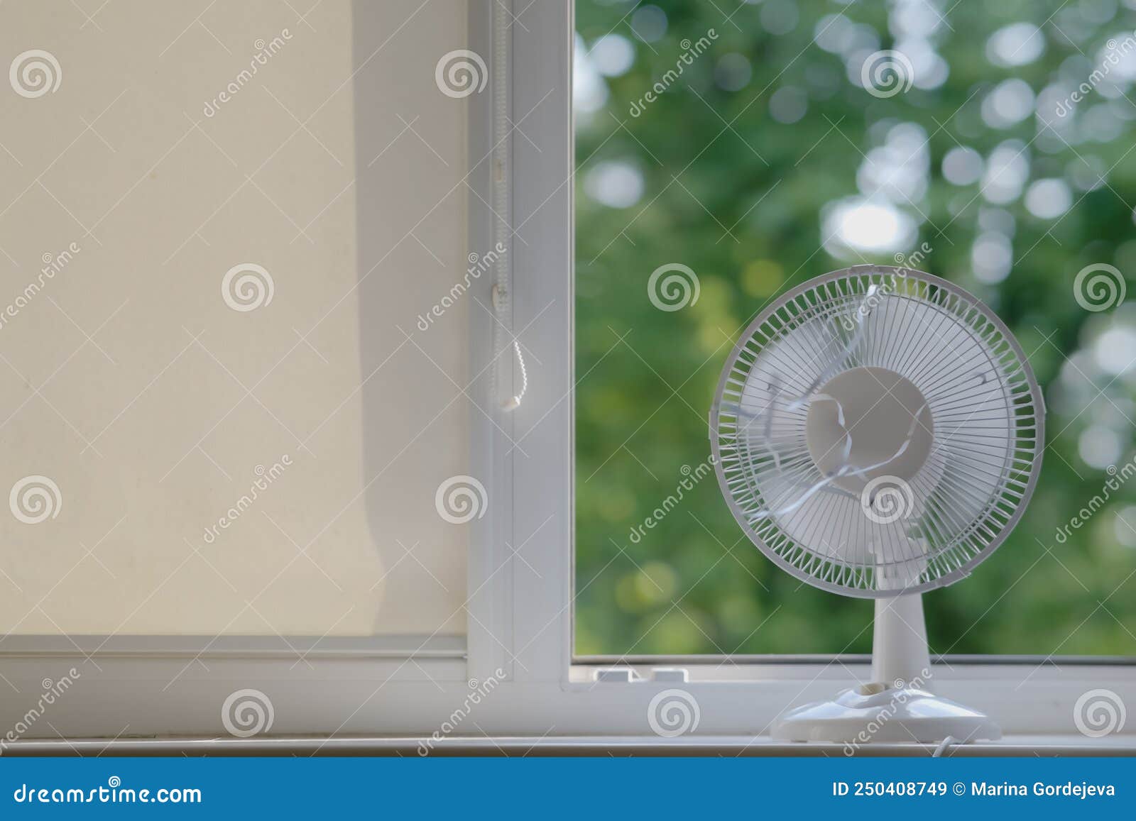 A Working Fan Stands on the Windowsill of an Open Window on a Hot ...