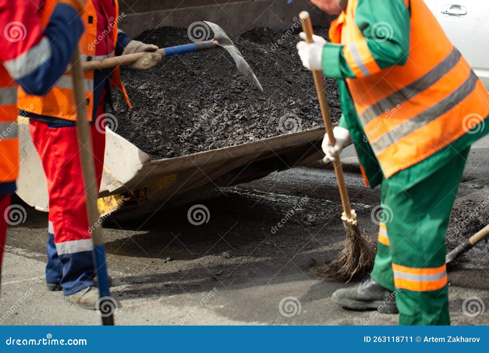A Working Group of Road Workers Loads the Old Asphalt into the Bucket ...