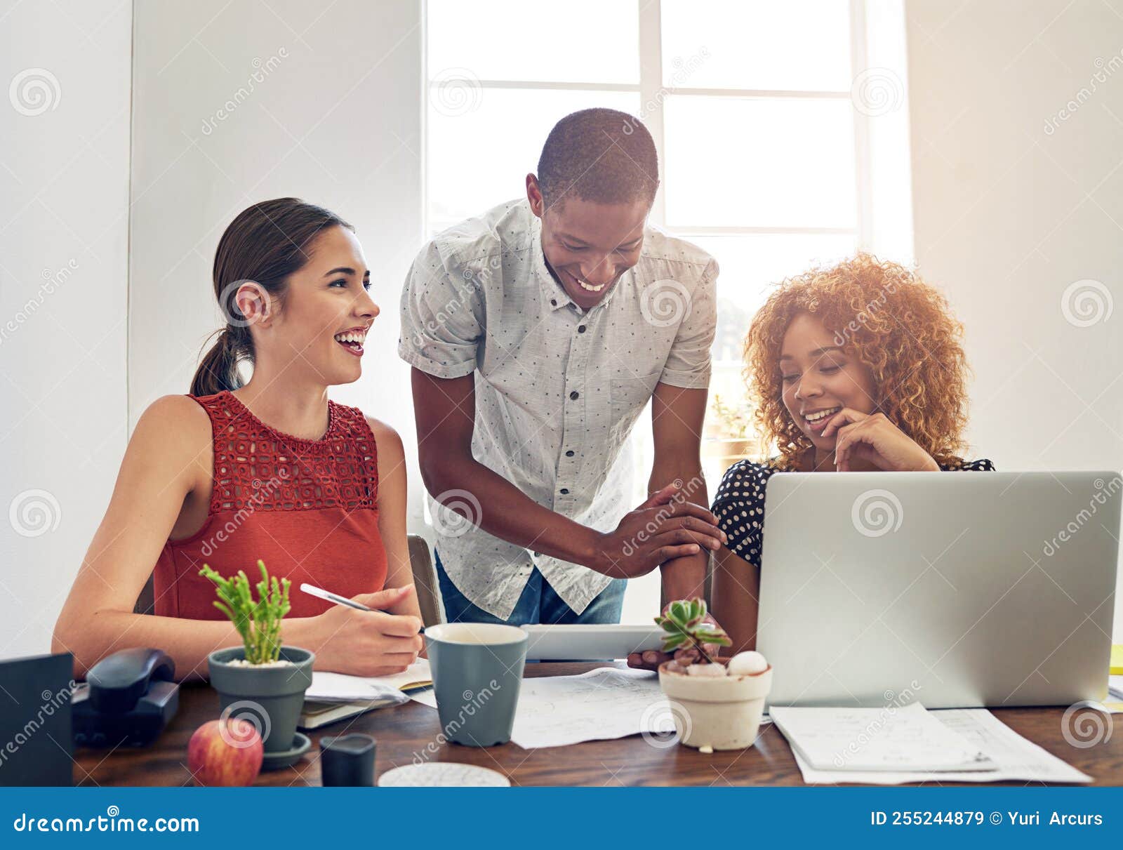 Working Hard and Having Fun. a Group of Colleagues Working Together at ...