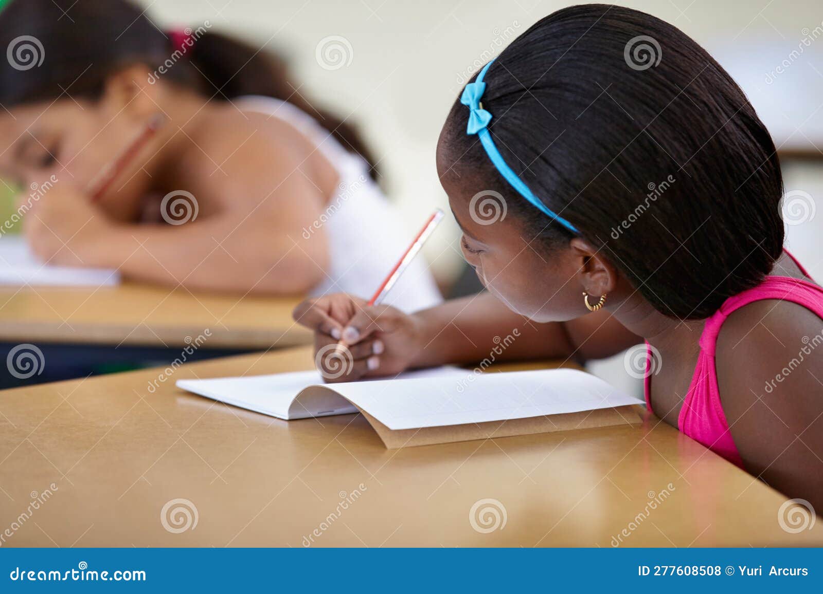 Working Hard at School. a Young Pupil Writing in a Workbook in a ...