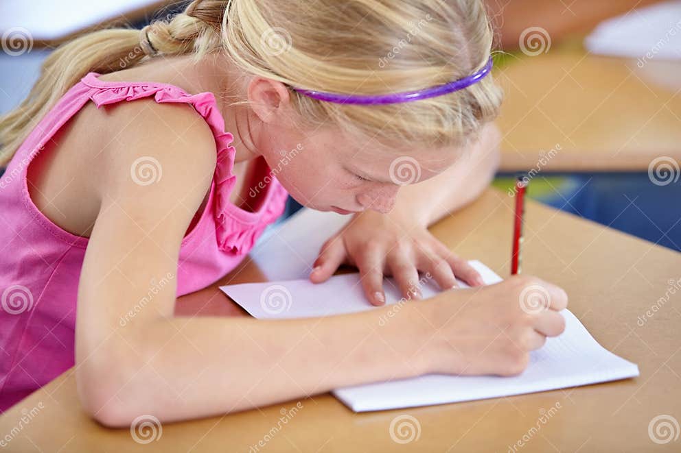 Working Hard at School. a Young Pupil Writing in a Workbook in a ...