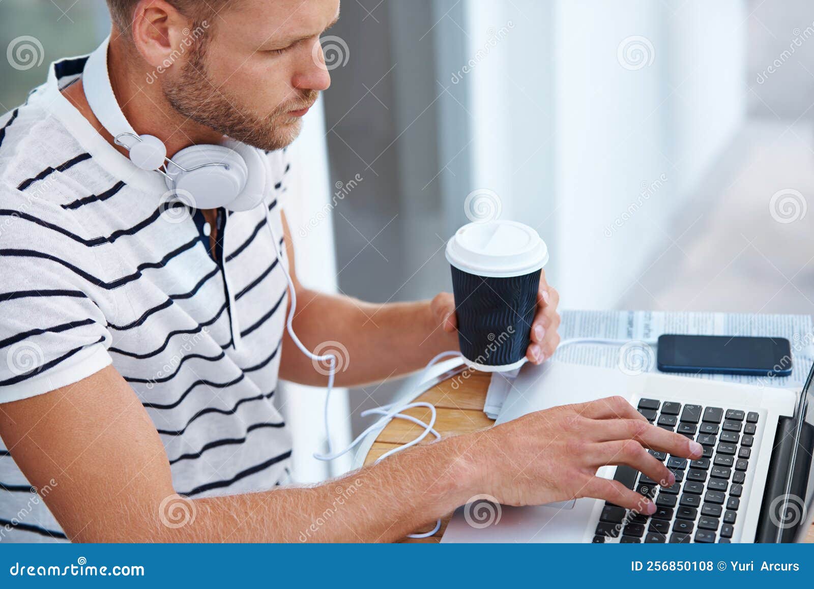 Working at His Own Pace. a Handsome Young Man Working on a Laptop ...