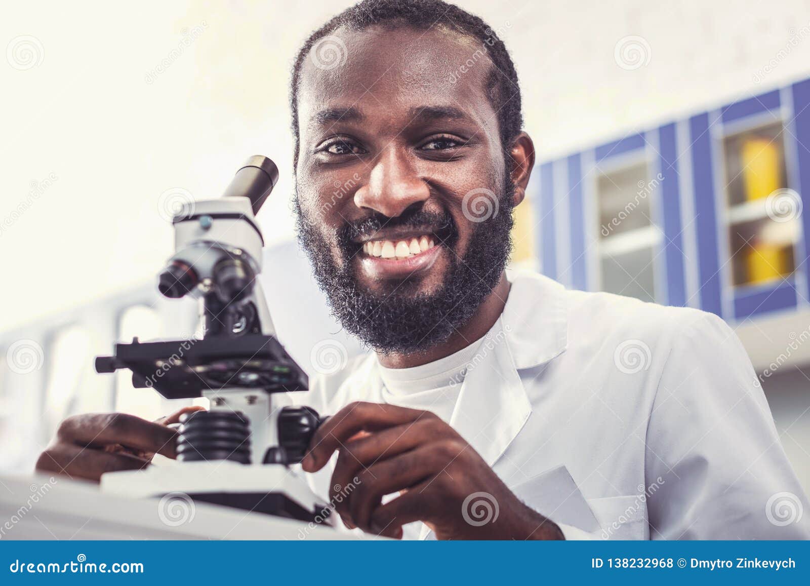 Smiling Microbiologist At Work Into Laboratory Using A Microscope ...