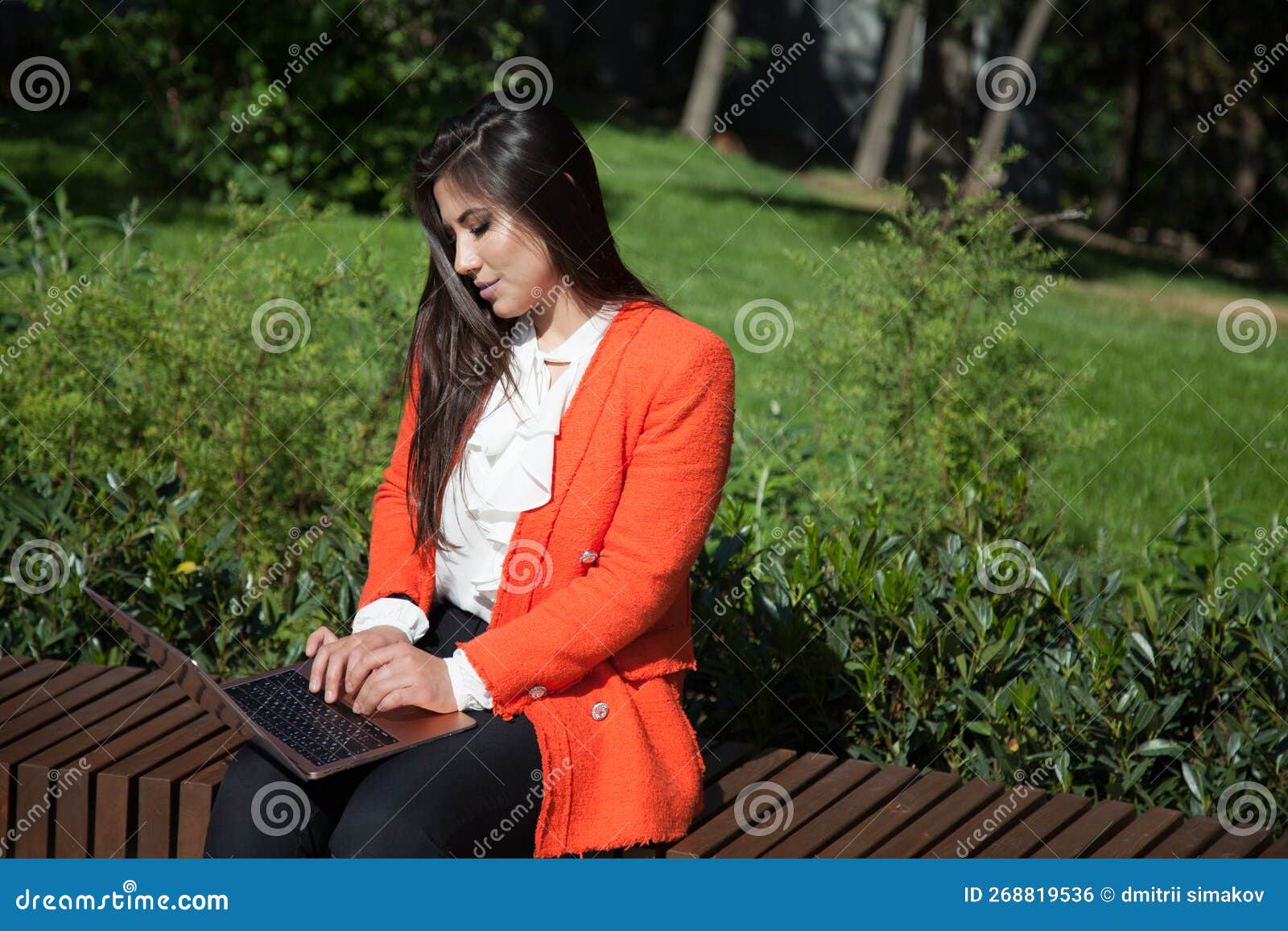 Working at a Laptop Outside Sitting on a Bench by Green Plants Stock ...