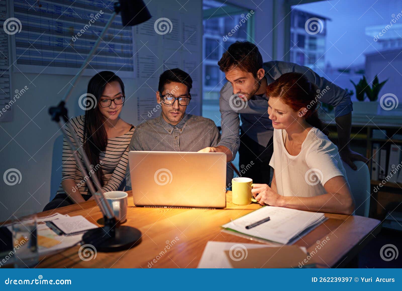 Working the Late Shift. Four Colleagues Working into the Night. Stock ...