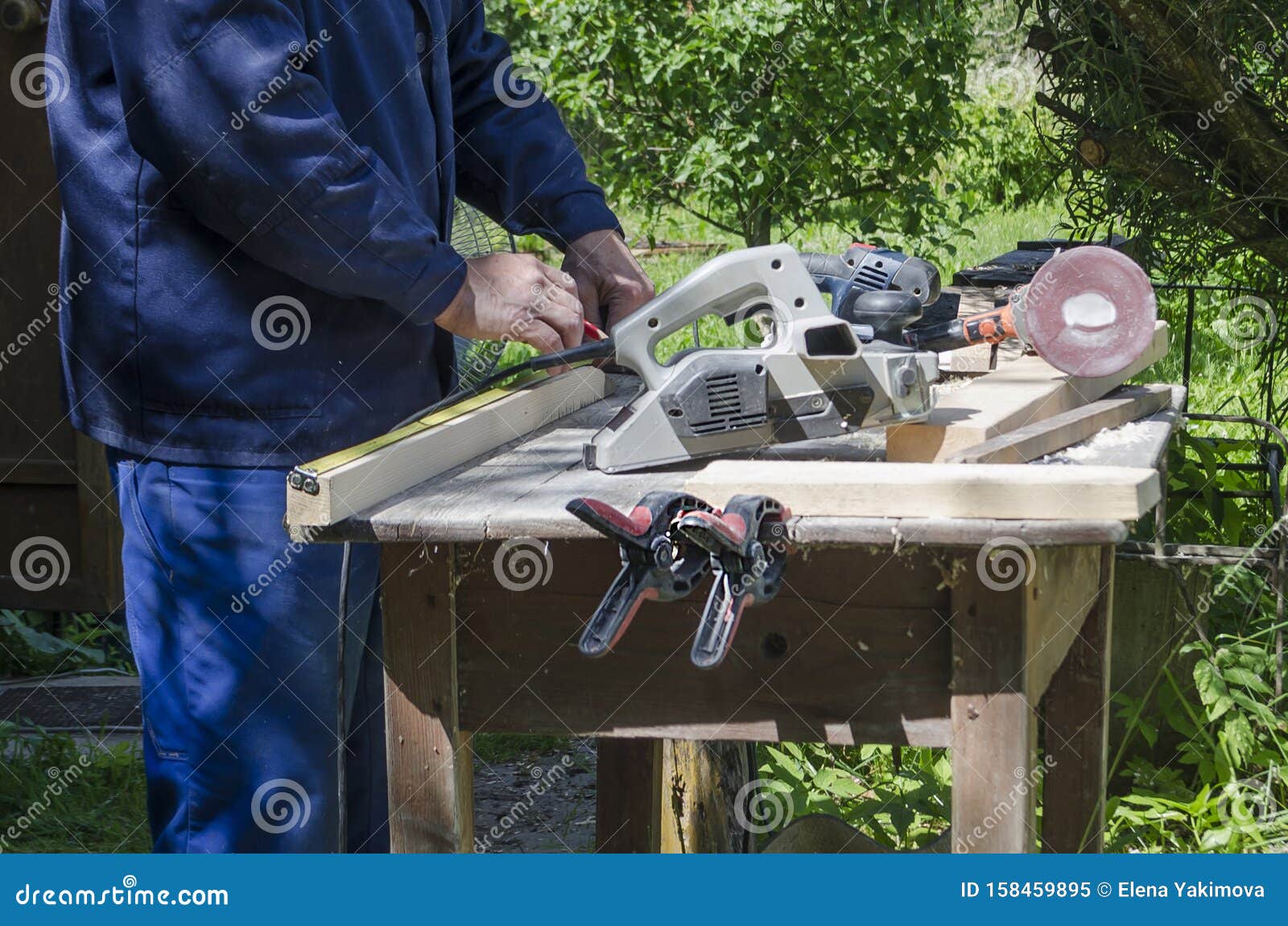 Working Man in a Blue Work Suit, a Carpenter in a Workshop Working with ...