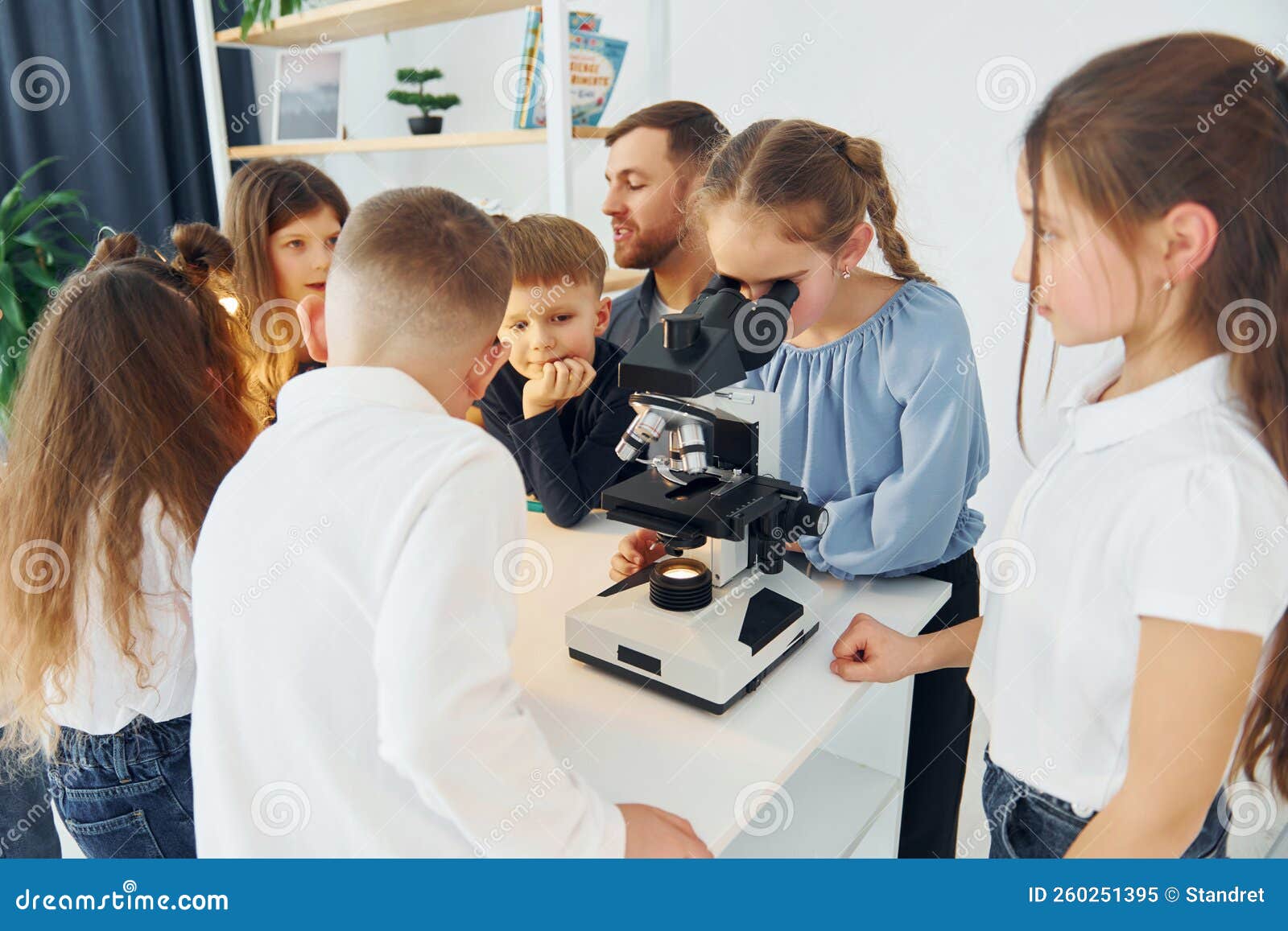 Working with the Microscope. Group of Children Students in Class at ...