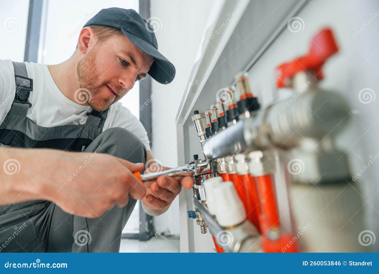 Working with Pipes. Repairman is Working Indoors in the Modern Room ...