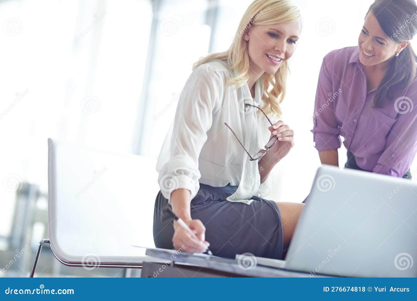 Working Together. Two Female Work Colleagues Looking at Something on ...