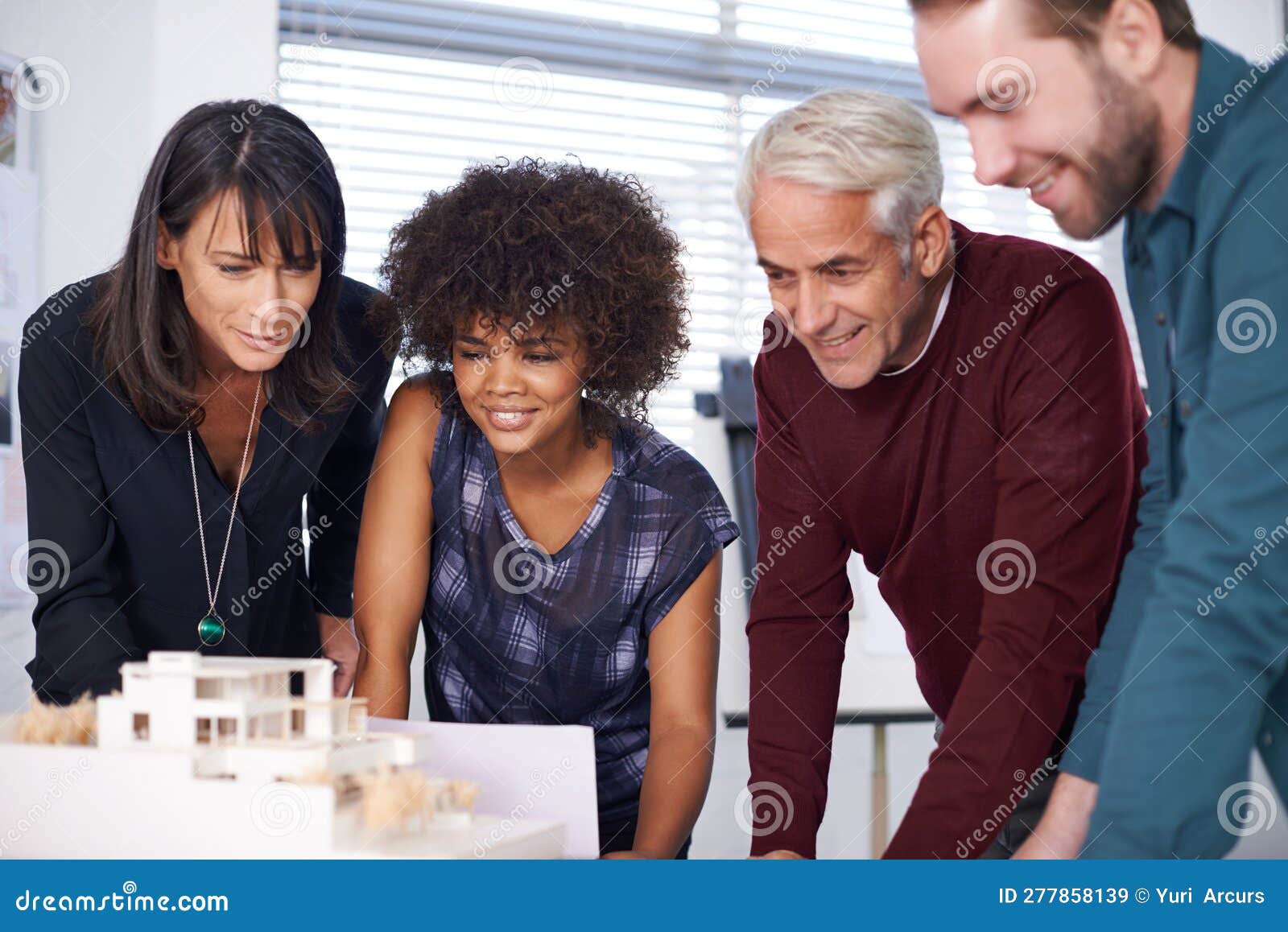 Working Towards a Common Goal. a Group of Architects Examining a Scale ...
