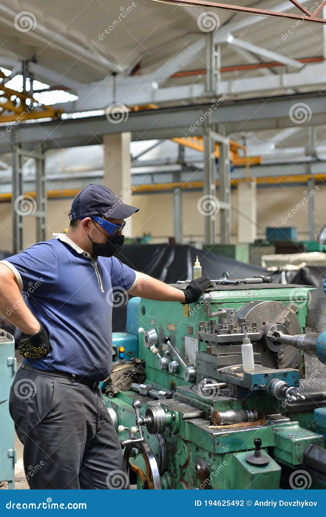 Working Turner Wearing a Protective Antiviral Mask on a Lathe in a ...
