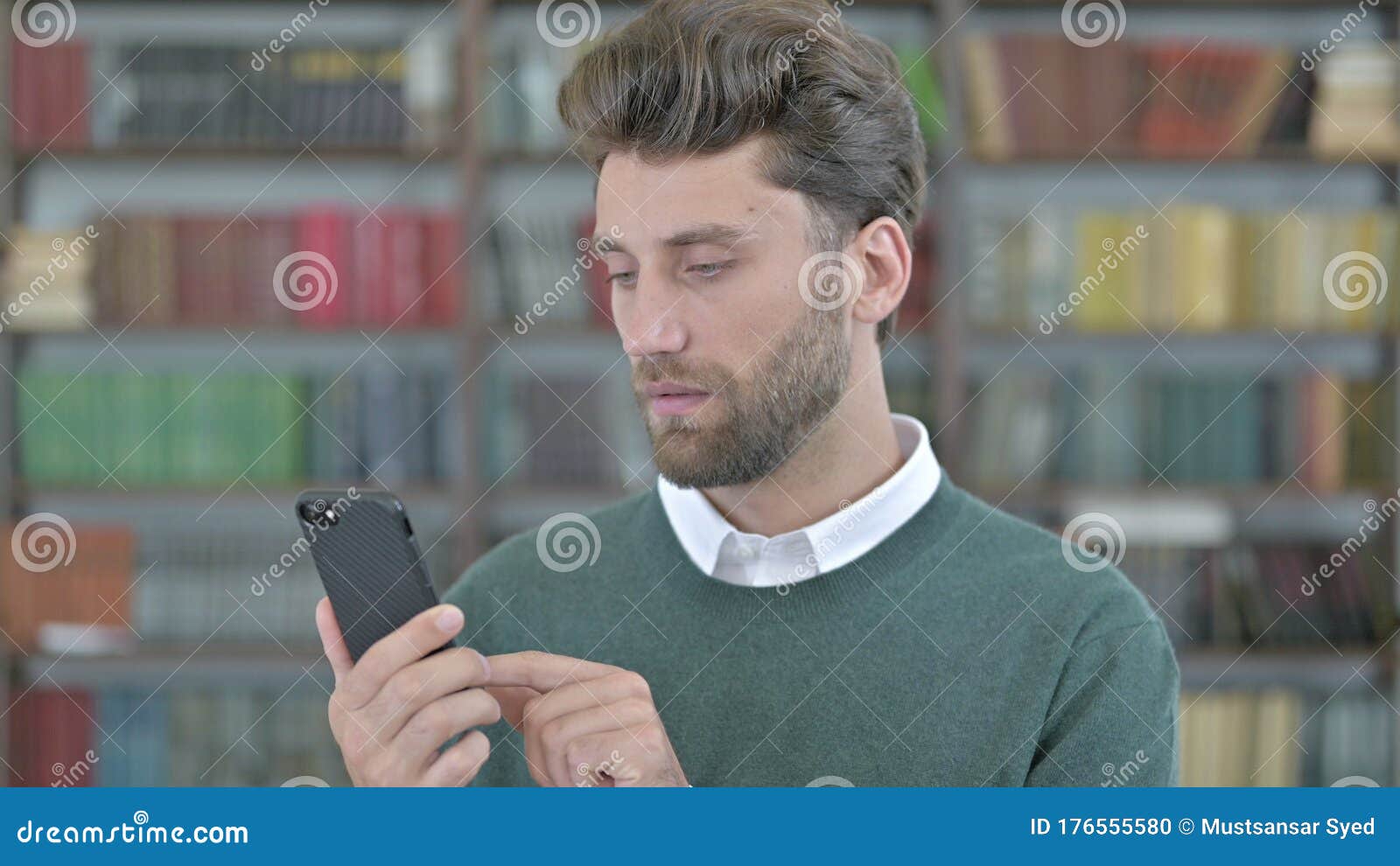 Working Young Man Scrolling His Smartphone and Smiling Stock Photo ...