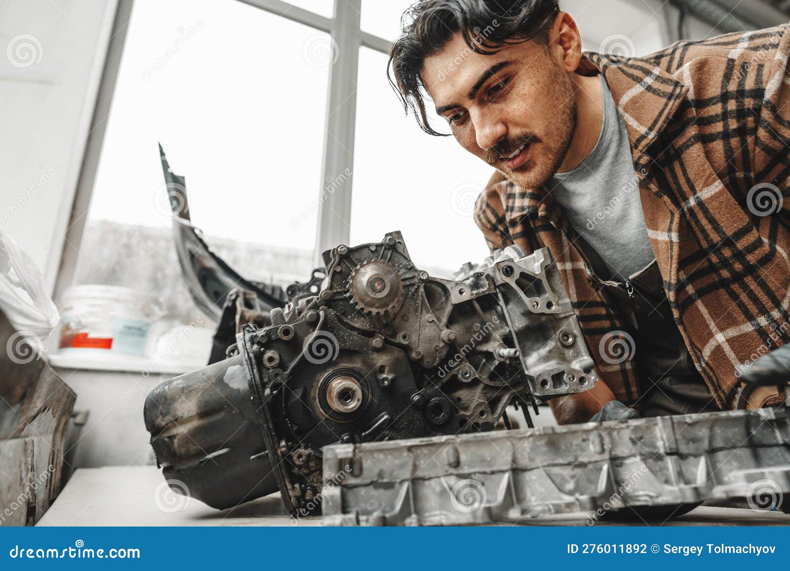 Workman Disassembling Car Engine at the Working Table of the Car ...