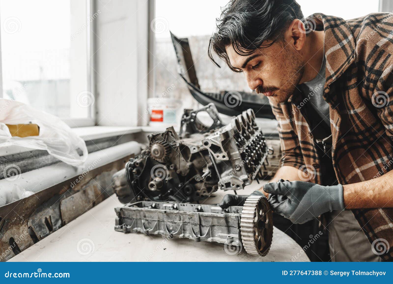 Workman Disassembling Car Engine at the Working Table of the Car ...