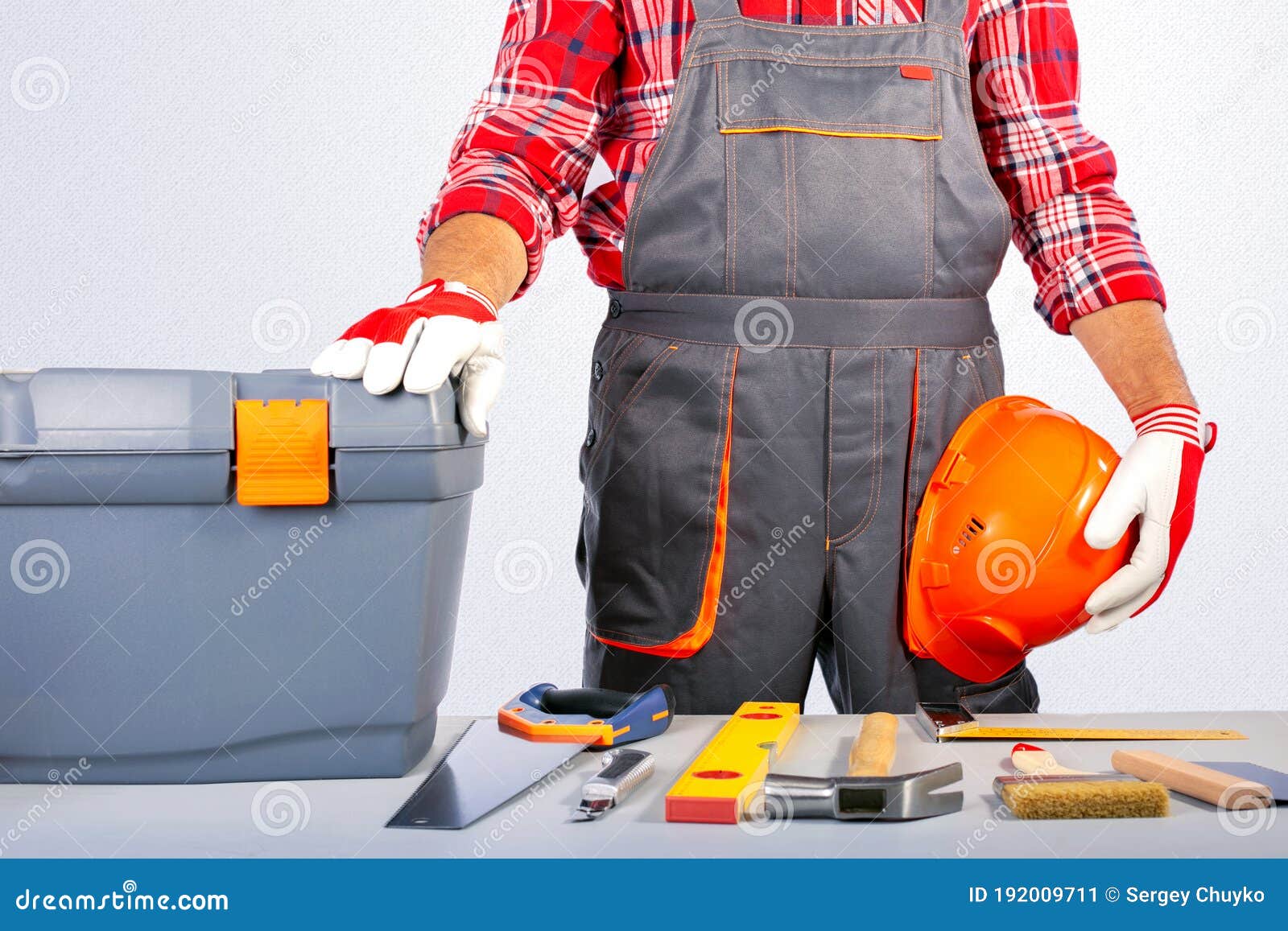 Workman in Grey Overall with Tool Box and Tools on the Table. House ...