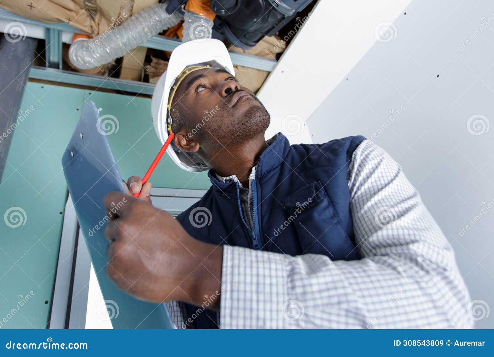 Workman Looking at Ventilation System and Making Notes on Clipboard ...