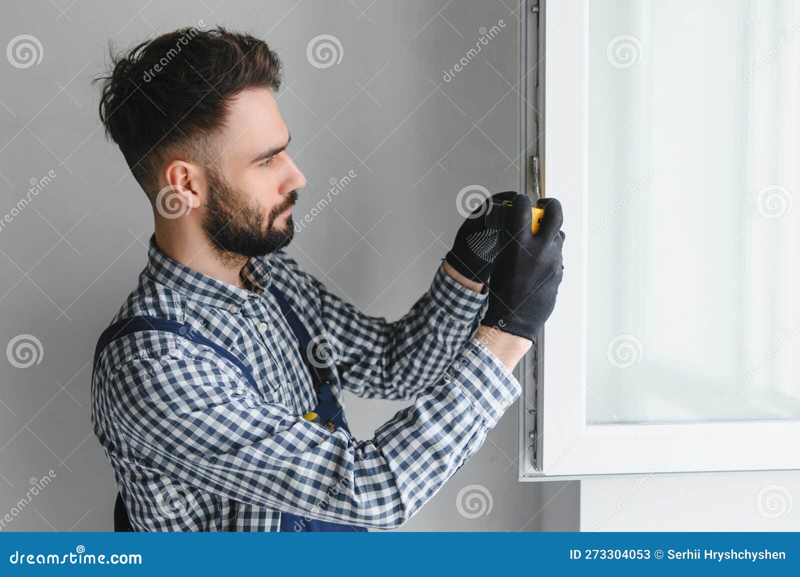Workman in Overalls Installing or Adjusting Plastic Windows in the ...