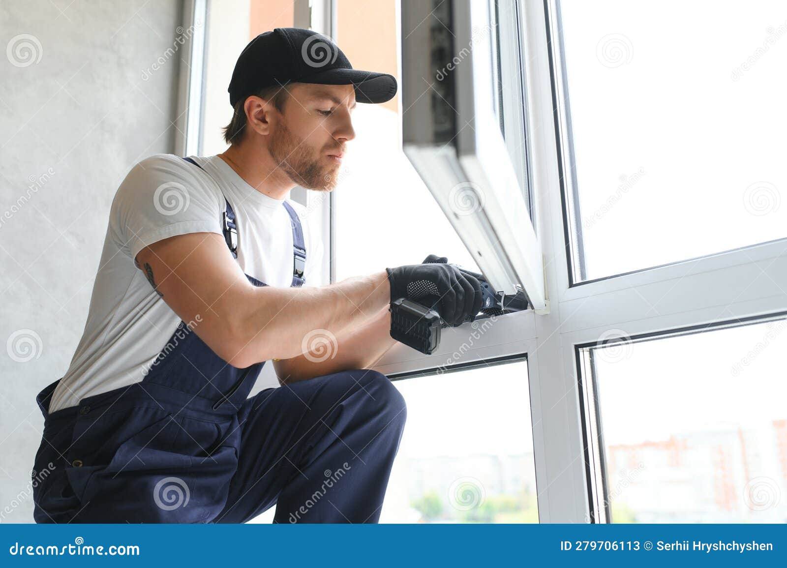 Workman in Overalls Installing or Adjusting Plastic Windows in the ...