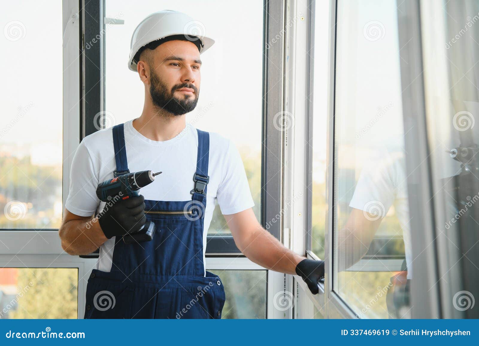 Workman in Overalls Installing or Adjusting Plastic Windows in the Living Room at Home Stock ...