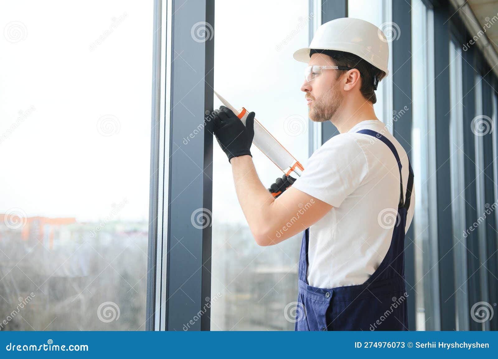 Workman in Overalls Installing or Adjusting Plastic Windows in the ...