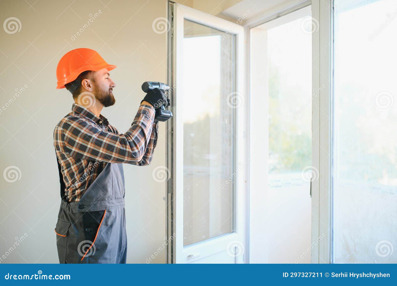 Workman in Overalls Installing or Adjusting Plastic Windows in the Living Room at Home Stock ...