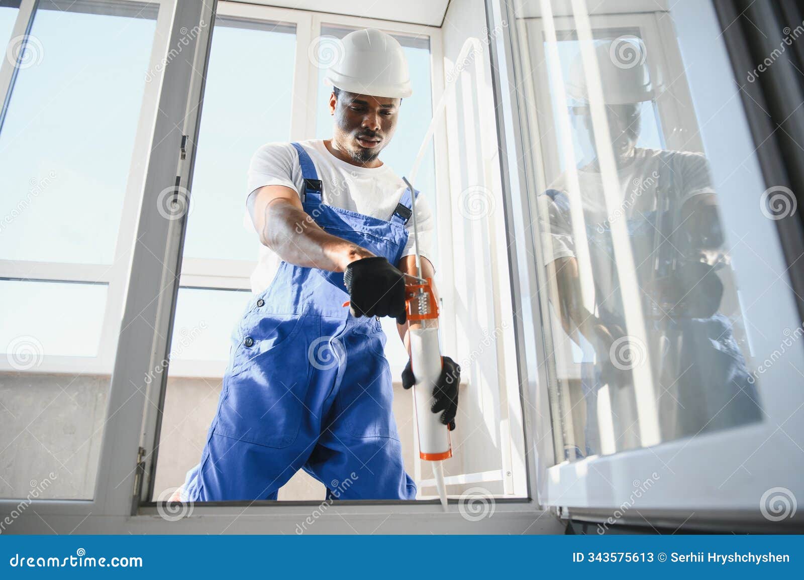 Workman in Overalls Installing or Adjusting Plastic Windows in the Living Room at Home Stock ...