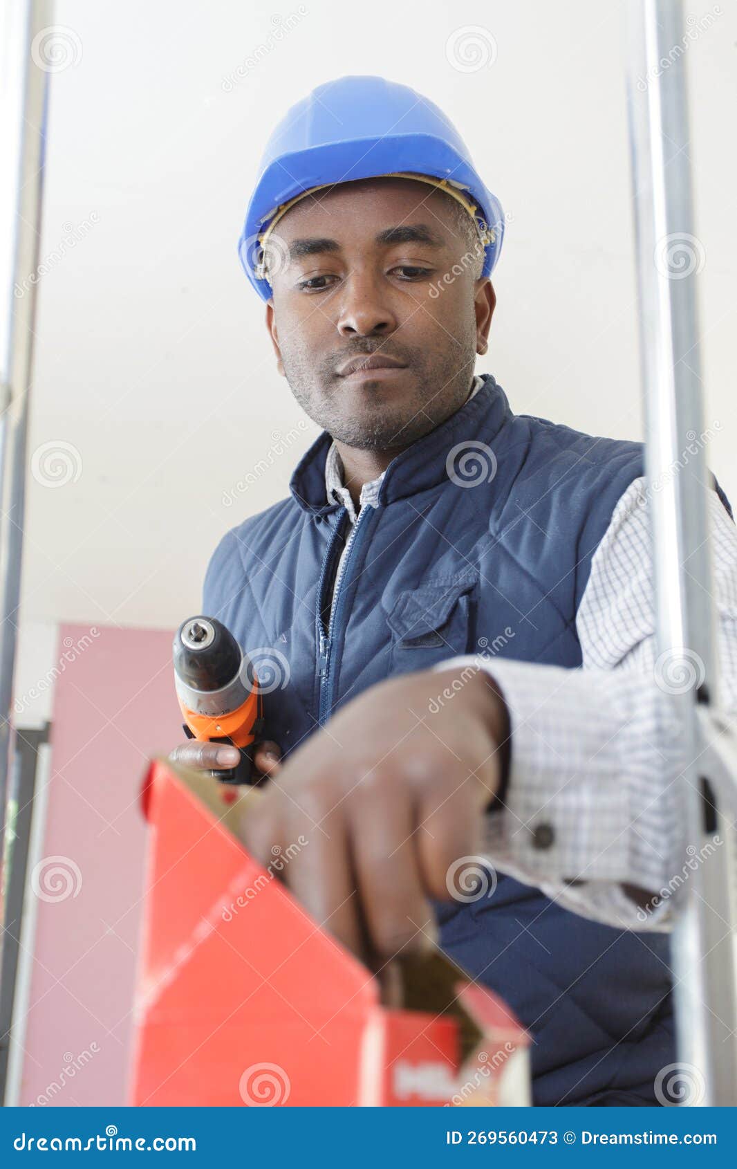 Workman with Power Screwdriver Reaching into Box for Screws Stock Image ...