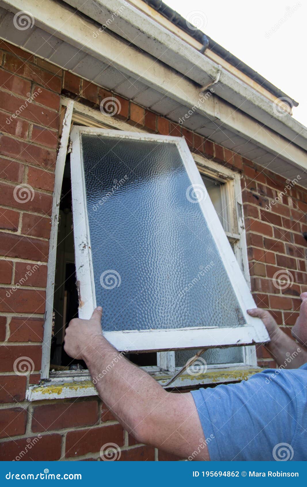 Workman Removing Broken Glass From Old Wooden Window Frame For ...