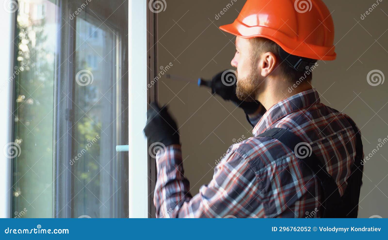 Workman in Uniform Installing or Adjusting Plastic Windows in the ...