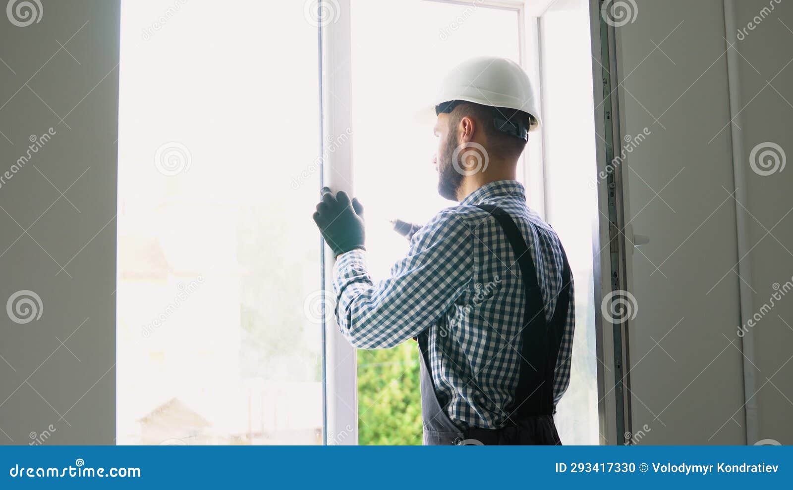 Workman in Uniform Installing or Adjusting Plastic Windows in the ...