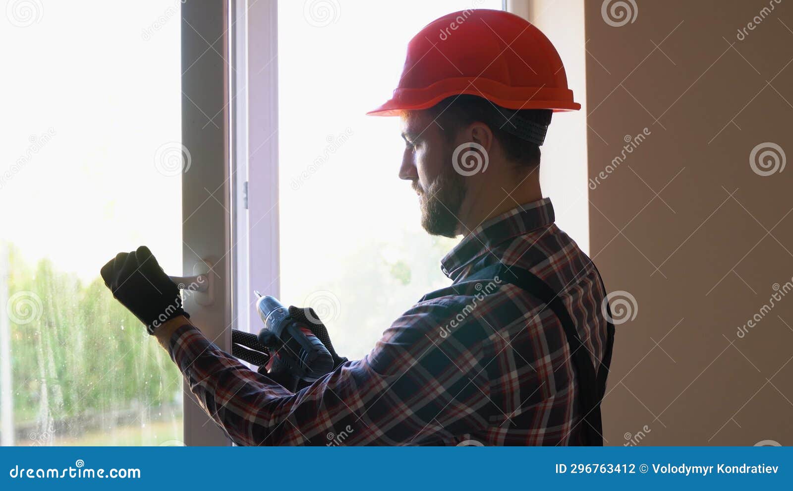 Workman in Uniform Installing or Adjusting Plastic Windows in the ...