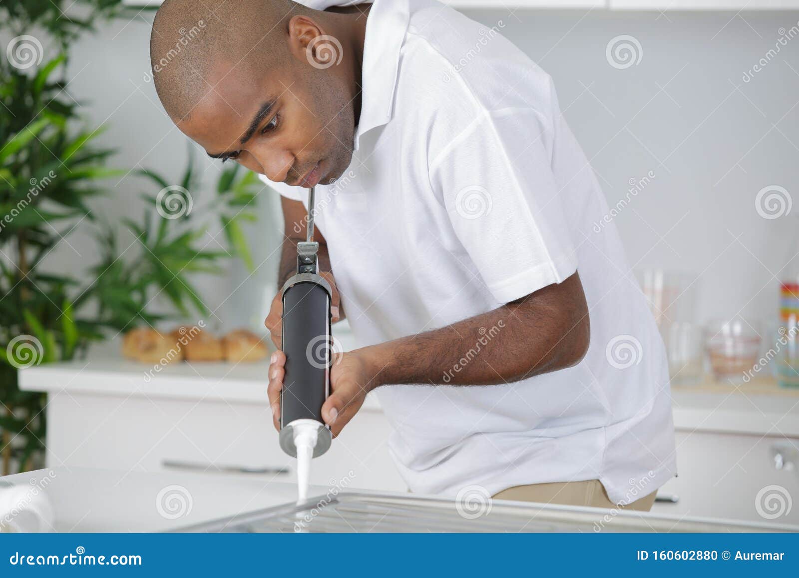 Workman using silicone gun stock photo. Image of countertop - 160602880