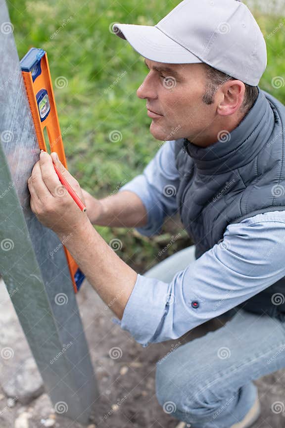 Workman Using Spirit Level on Metal Post Stock Photo - Image of post ...