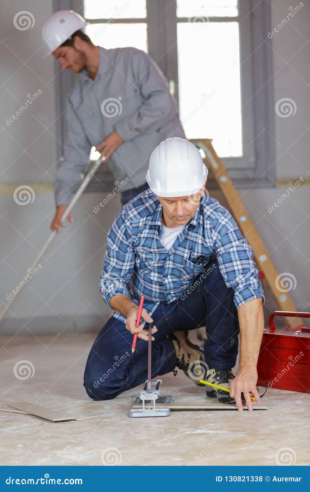 Workman using tile cutter stock photo. Image of tile - 130821338