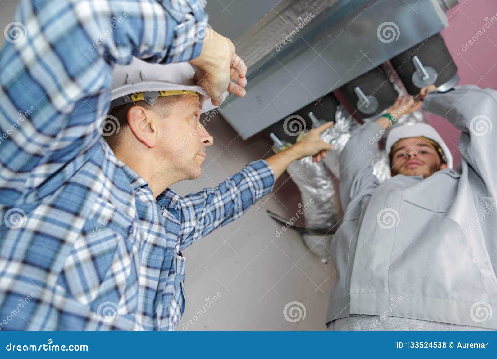 Workmen Fitting Overhead Ventilation Pipes Stock Photo - Image of ...