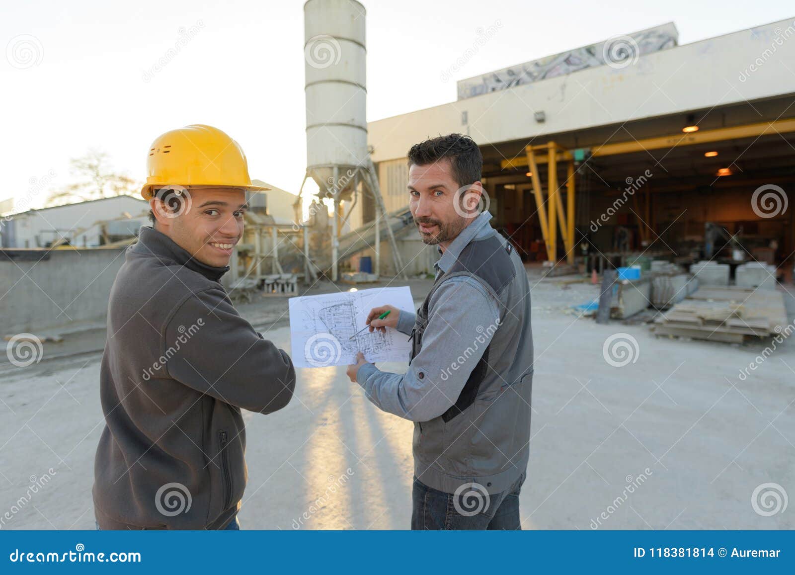 Workmen Looking at Plans on Worksite Stock Photo - Image of portrait ...