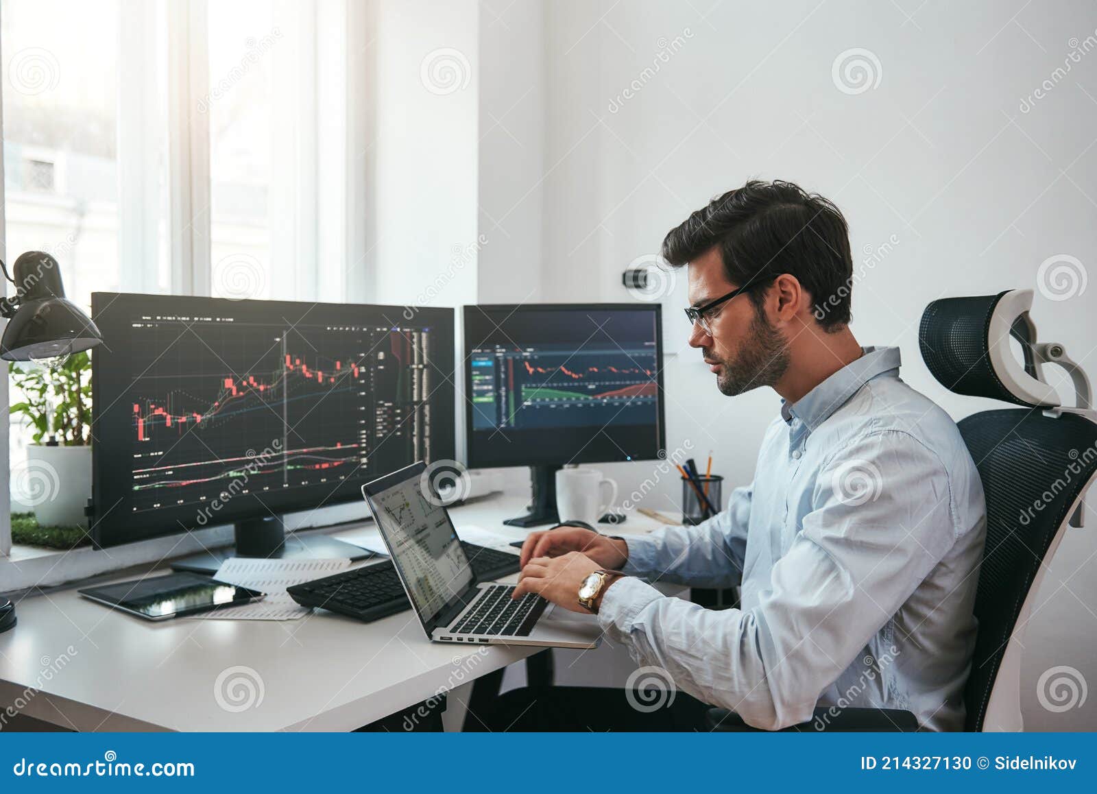 Workplace of Trader. Young Bearded Trader Wearing Eyeglasses Using His ...