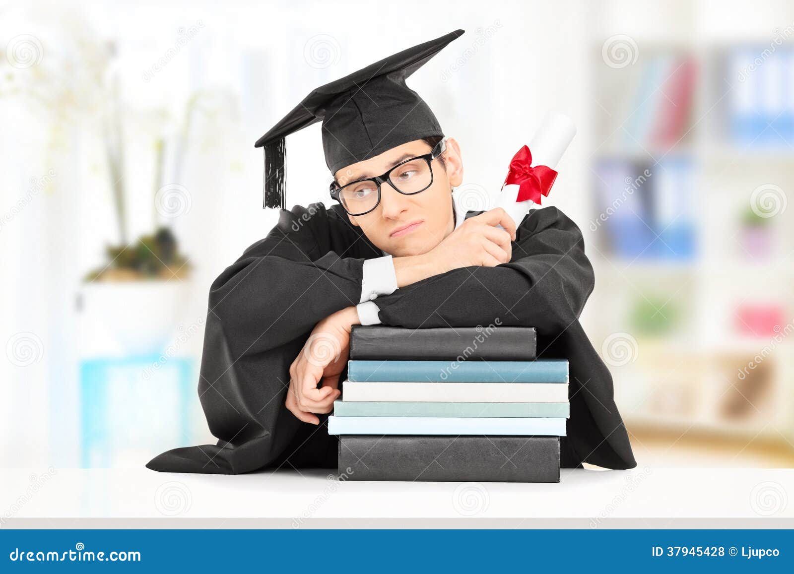 Worried College Graduate Leaning on Stack of Books, Indoors Stock Photo ...