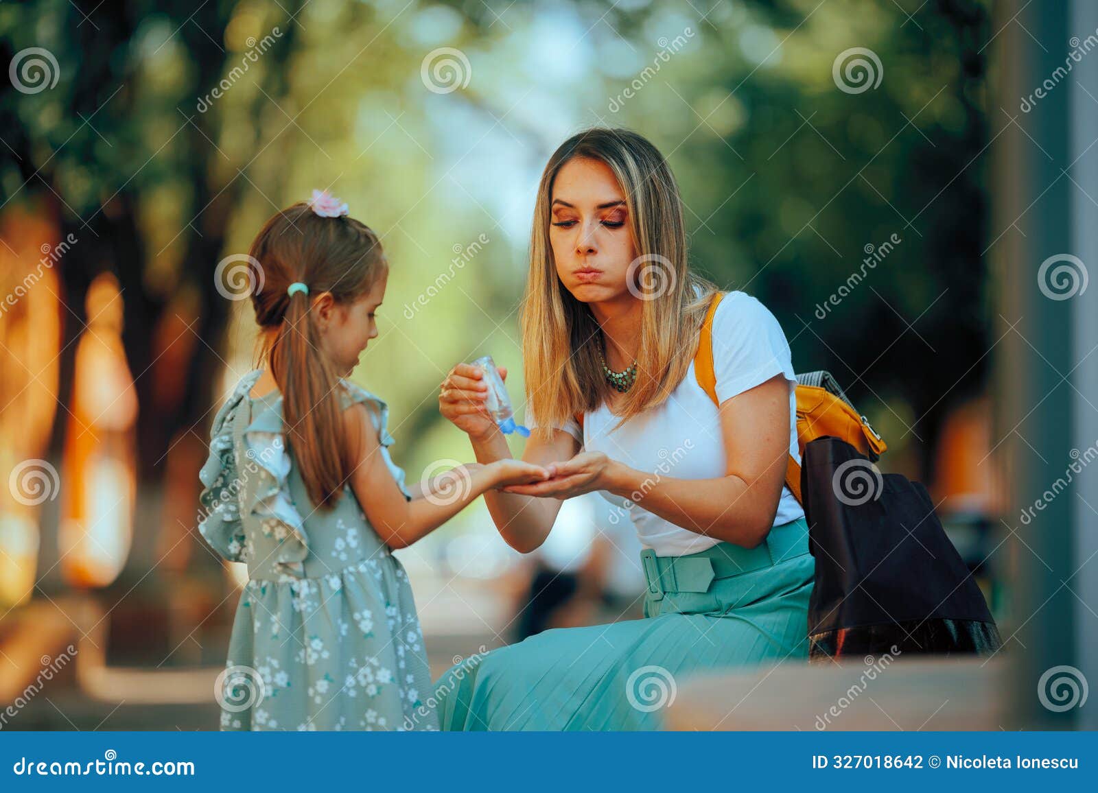 Worried Mom Using Sanitizing Hand Gel Outdoors at Playtime Stock Photo ...