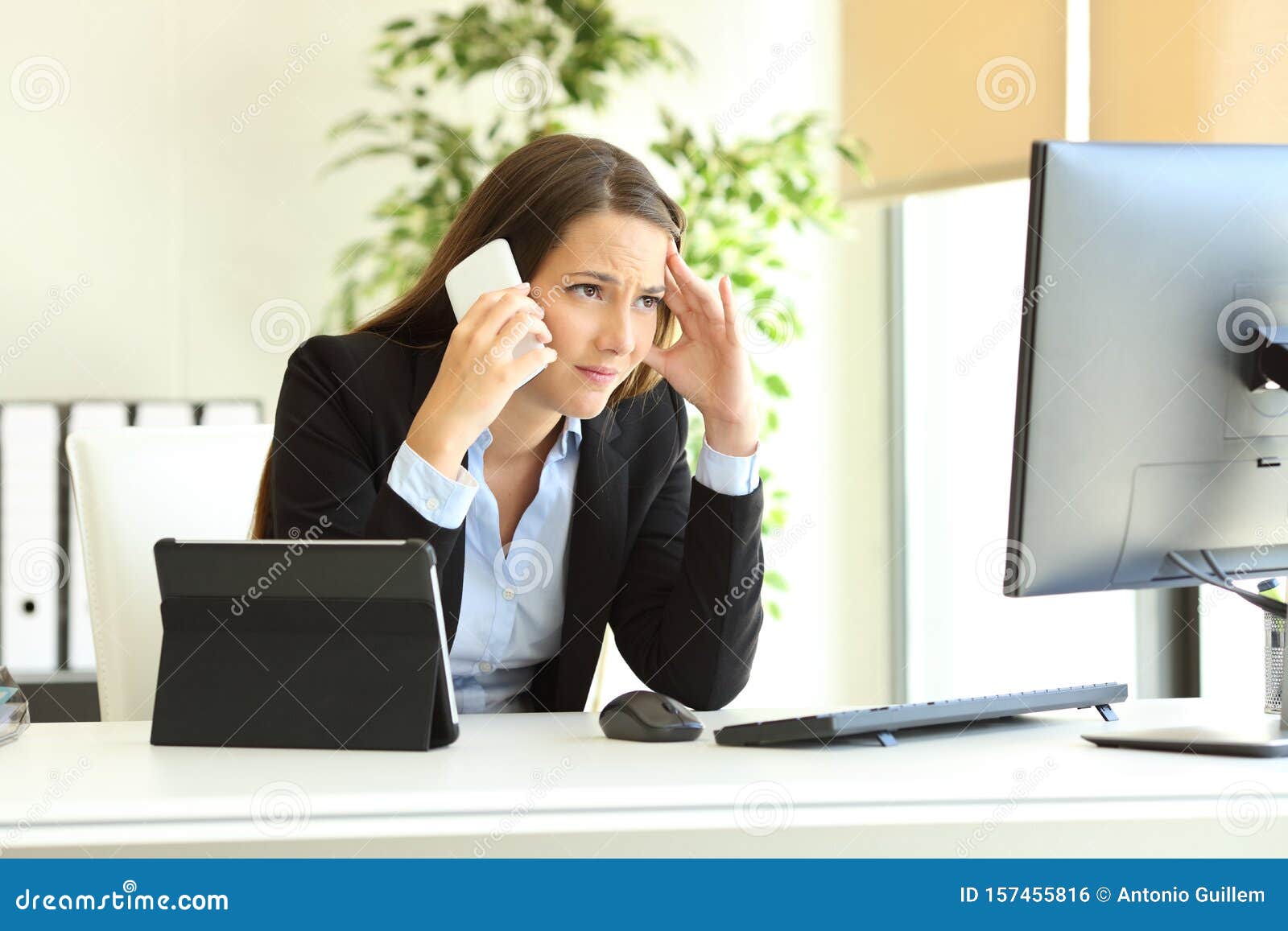 Worried Office Worker Using Multiple Devices Calling on Phone Stock ...