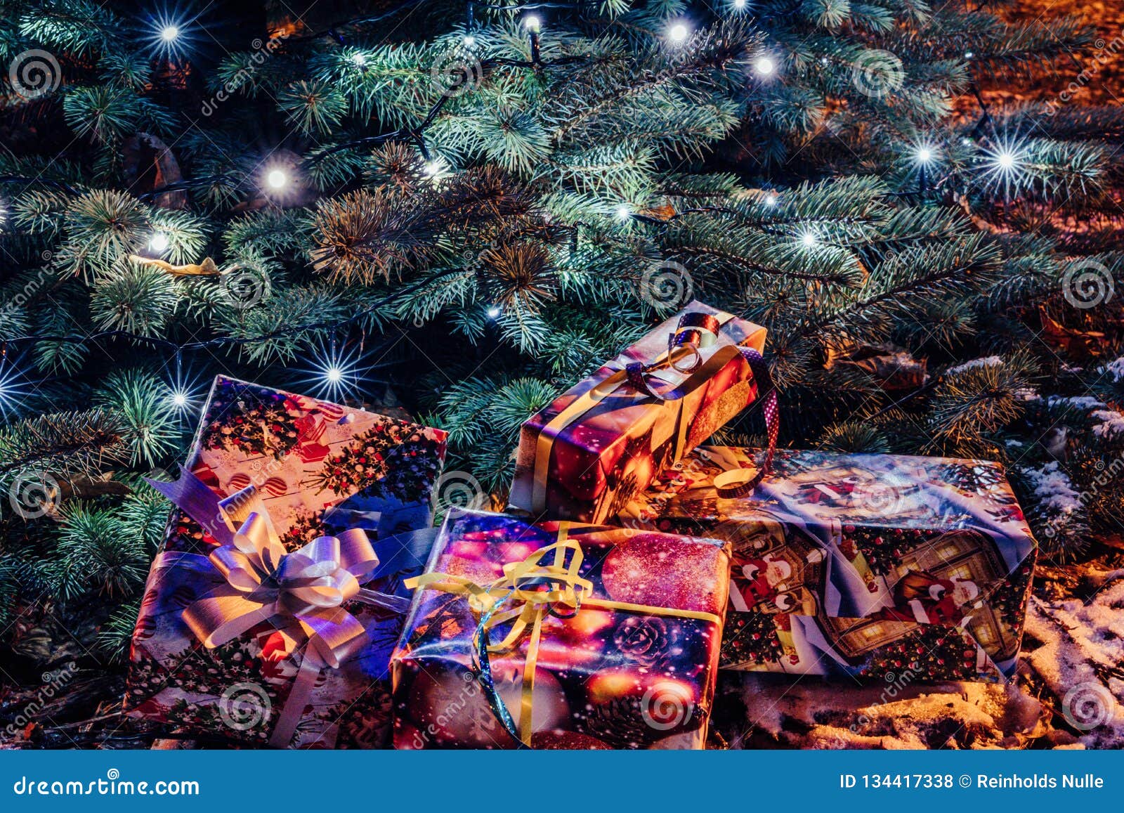 Wrapped Christmas Presents Under the Christmas Tree with Lights Stock ...