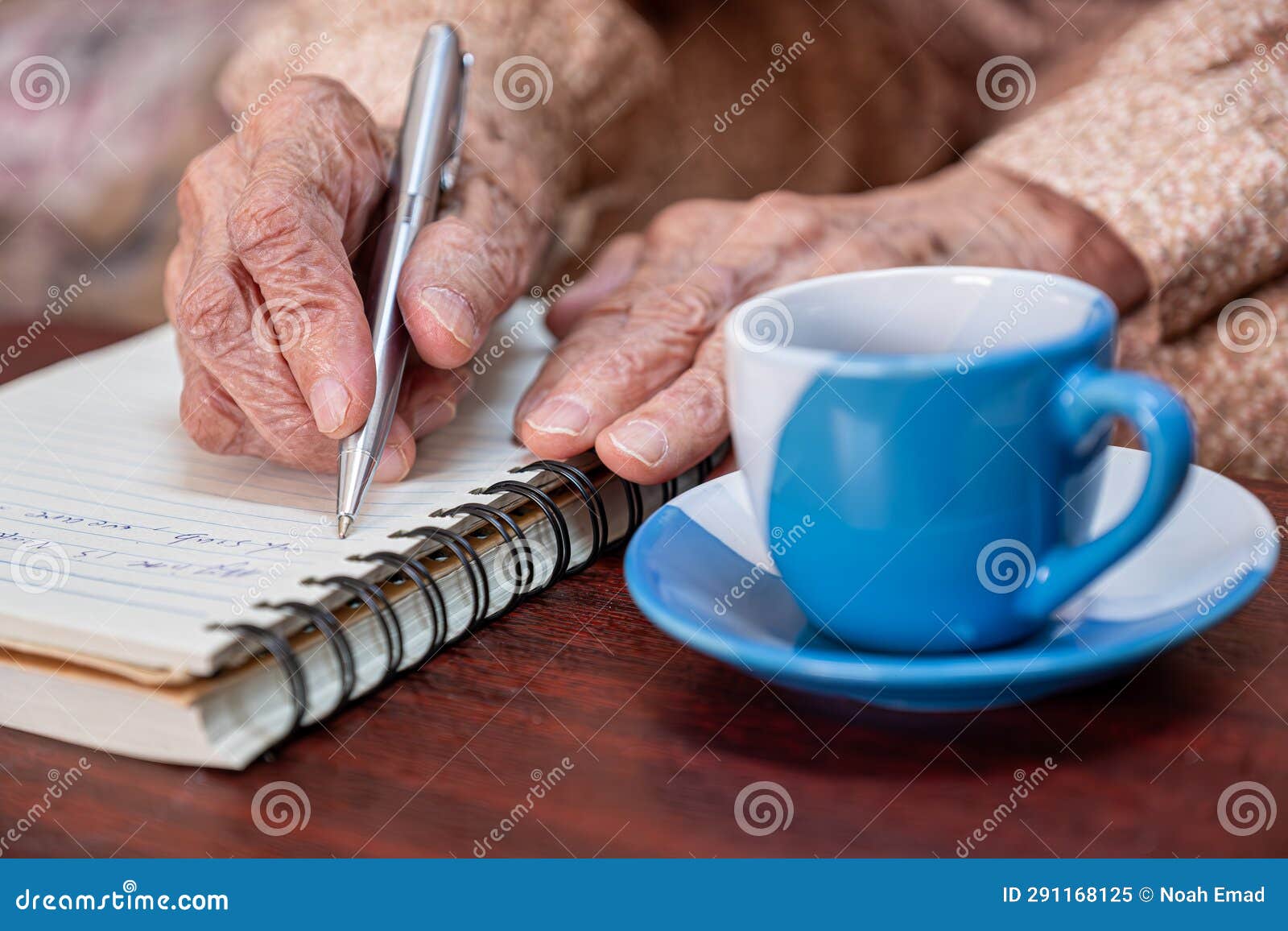 Wrinkled Hands for Elderly Person Writing Notes on His Note Book while ...