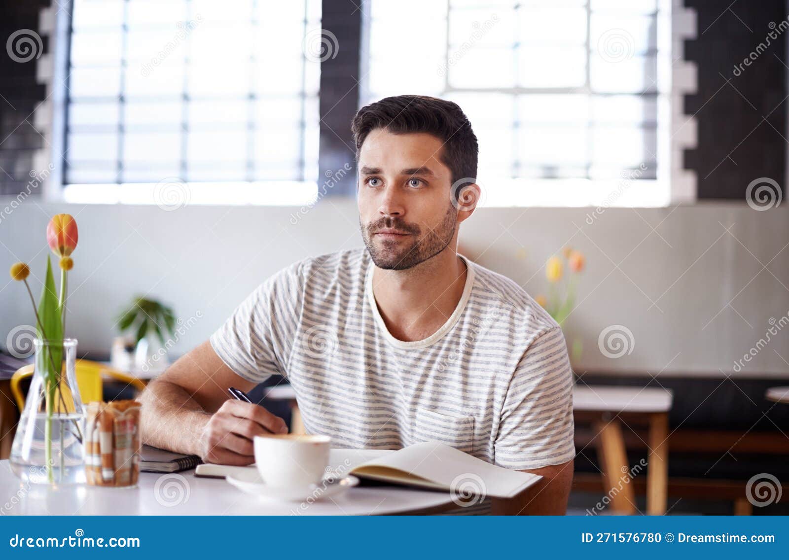 The Write Stuff. a Handsome Young Man Writing in a Notebook while ...